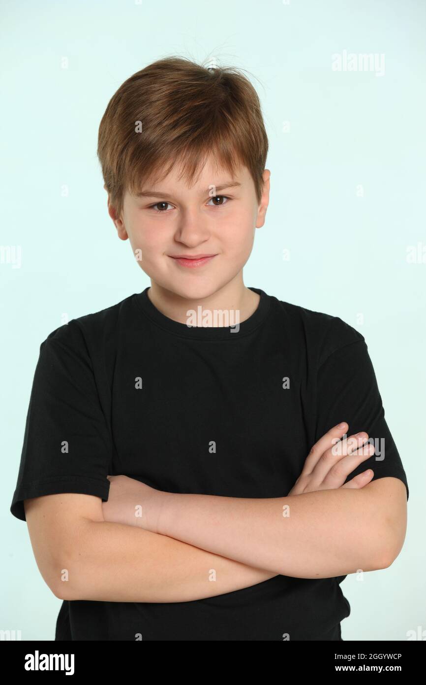An intelligent teenage boy looks into the eyes with a smile and is ...
