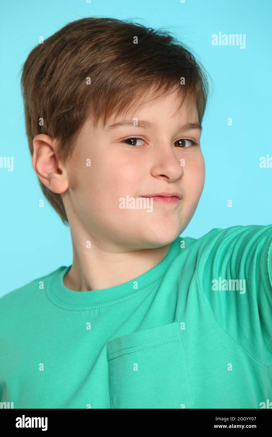 Close-up portrait. Handsome cheerful young teenage boy cheerfully looks ...