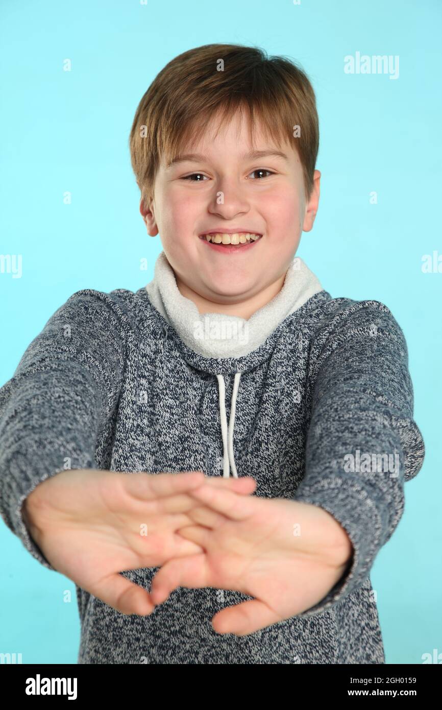 In the portrait, a handsome teenage boy smiles and stretches, rejoices ...