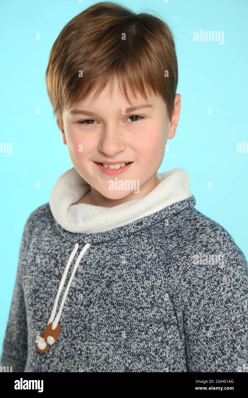 Close-up portrait: a handsome, talented teenage boy smiles with a sly ...