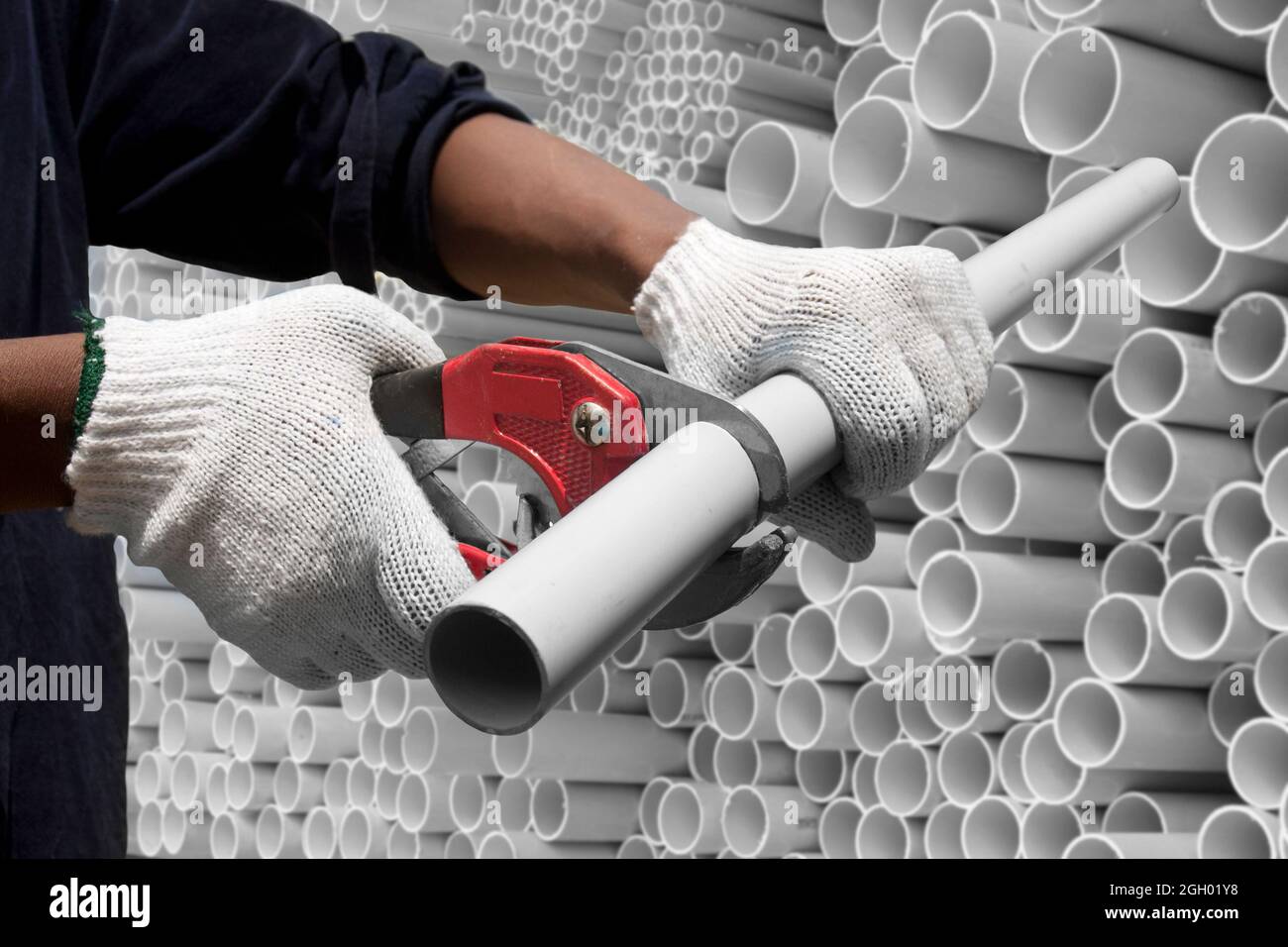 Worker cutting pvc pipe in construction site Stock Photo - Alamy