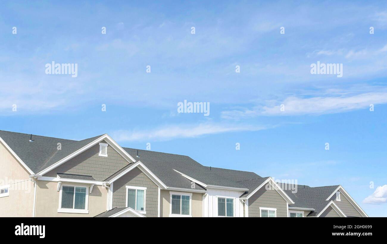 Pano Front view of townhouses against blue sky on a suburban ...