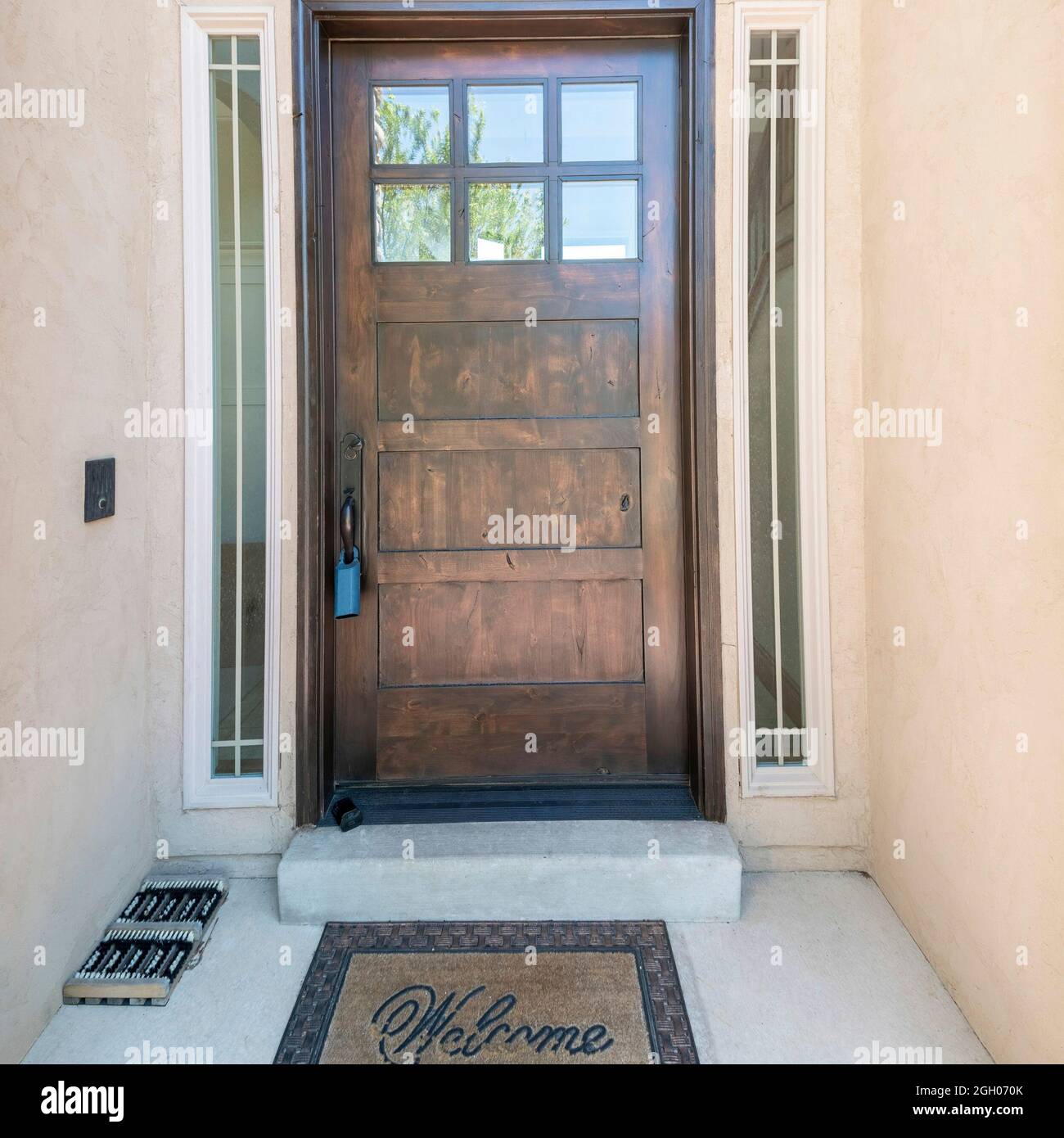 Square frame Exterior of a front door with glass panels and doormat ...