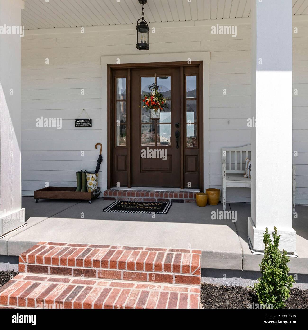 Square frame Exterior of a house with brick stairs, plants and white ...