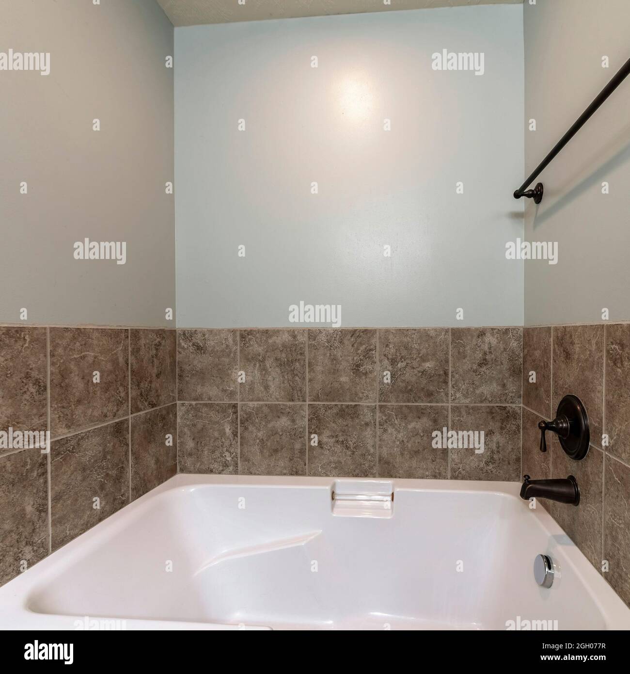 Square frame Bathroom interior with drop in tub with brown tile ...