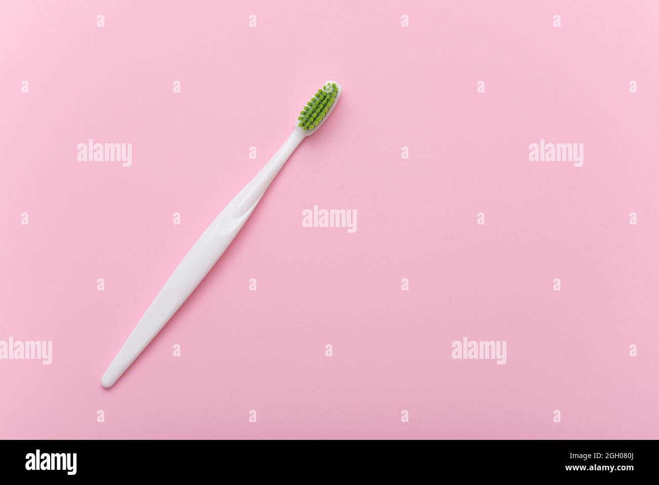 White plastic toothbrush with green bristle as flat lay. Toothbrush on ...