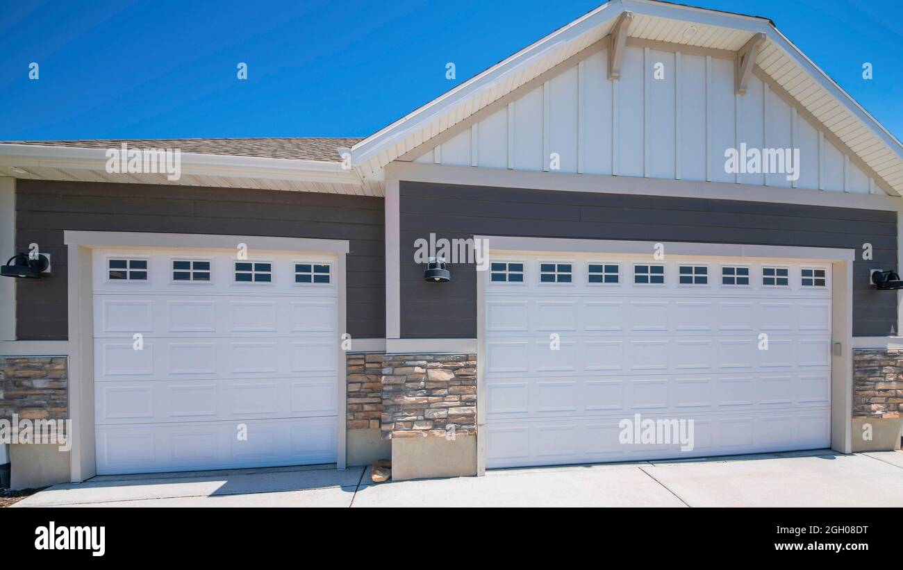 Pano Home exterior with white double garage doors with windows and half ...