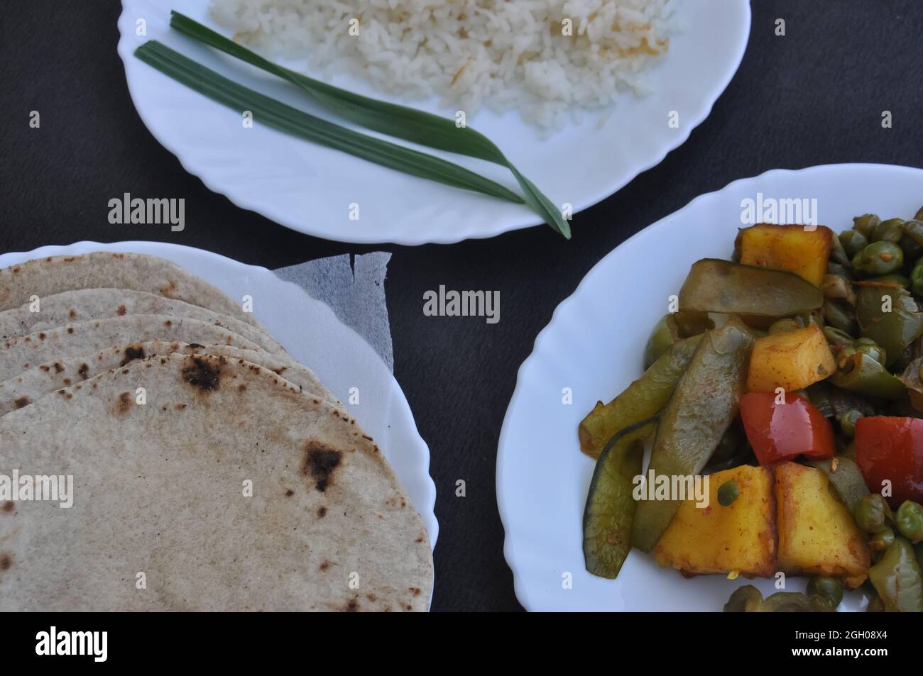 Closeup of matar paneer veg, roti (Indian bread) and rice on white ...