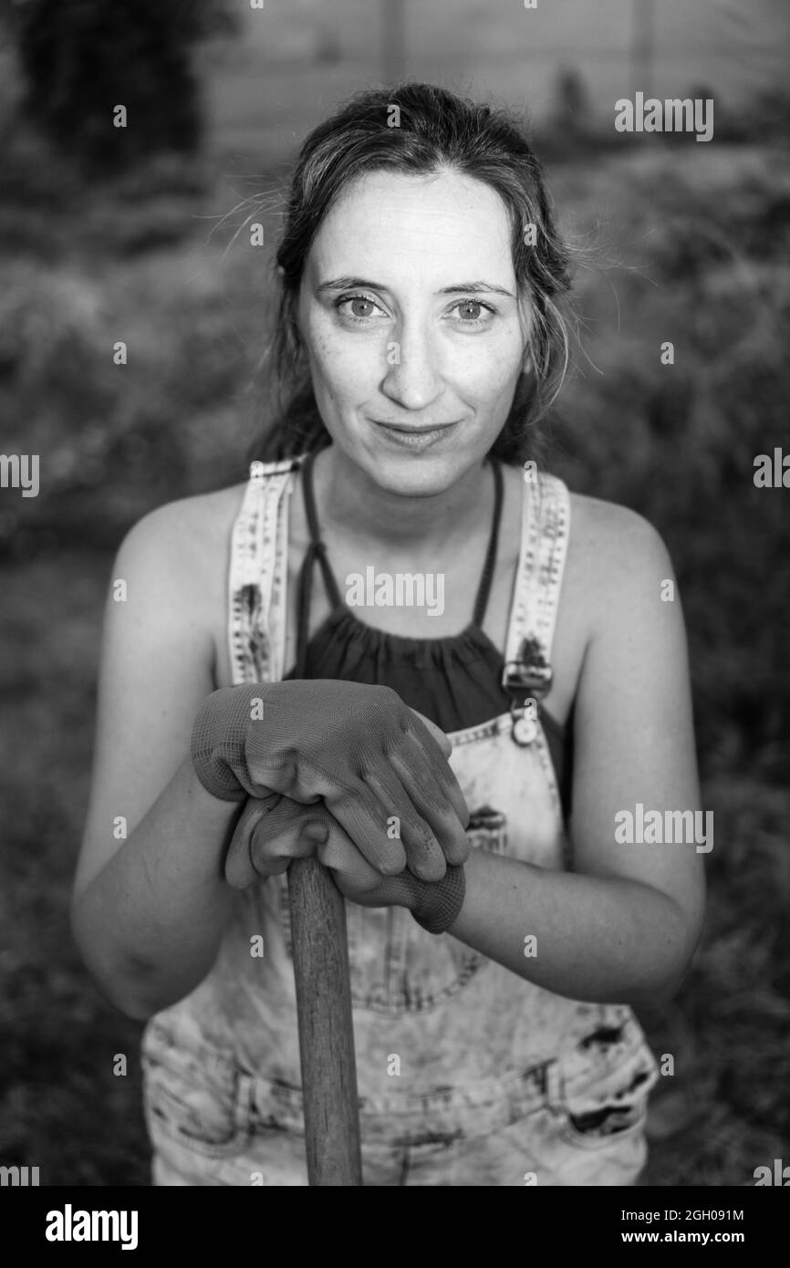Black and white portrait of a woman working in the field with gloves on ...