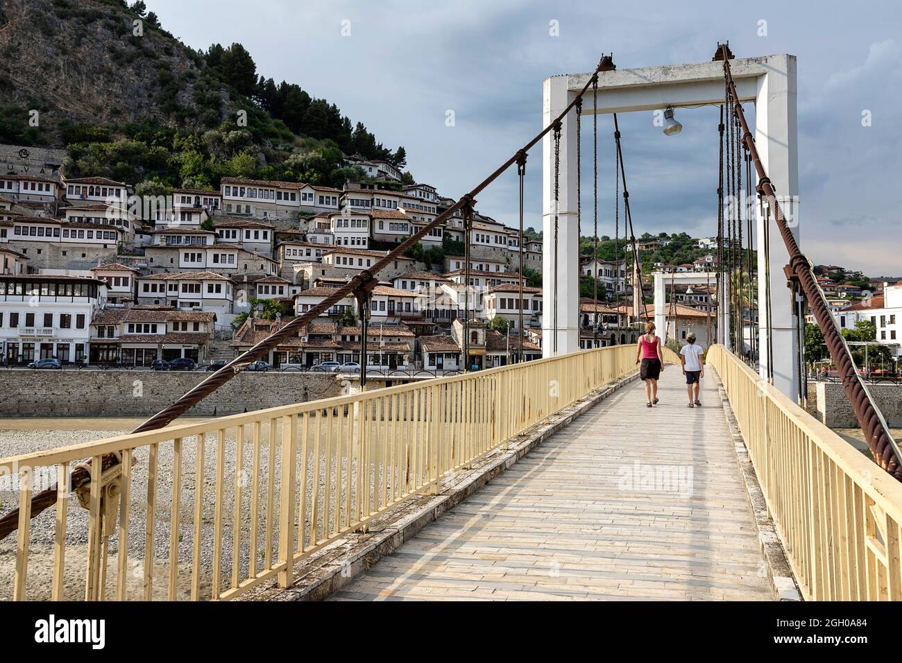 Tourist crossing the bridge in an old part of the city of berat in ...
