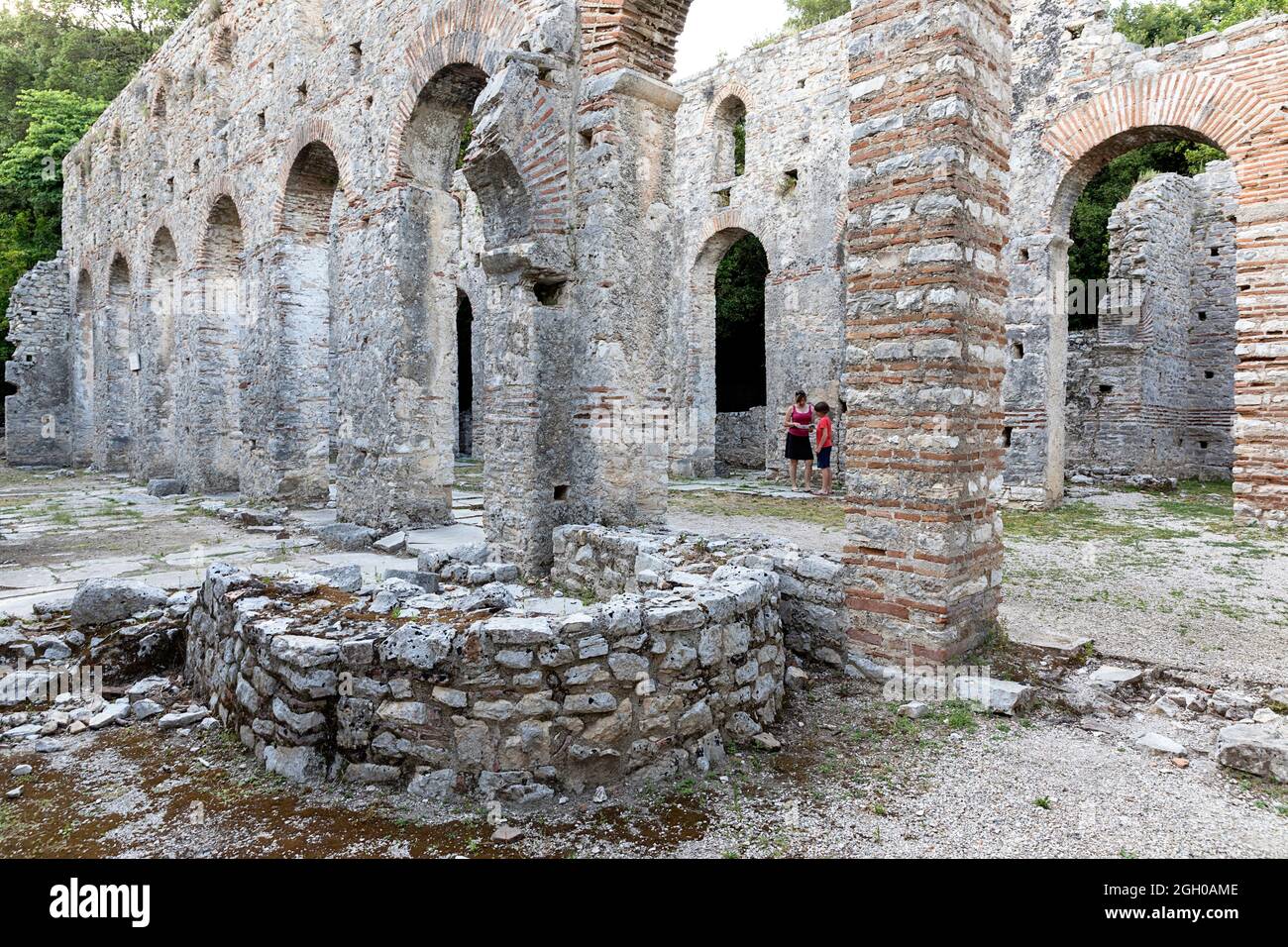 Mother and son walking among the ruins of ancient city of Butrint in ...