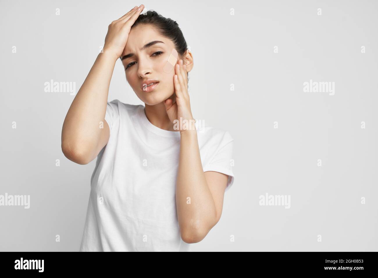 brunette holding his head trauma health problems isolated background ...