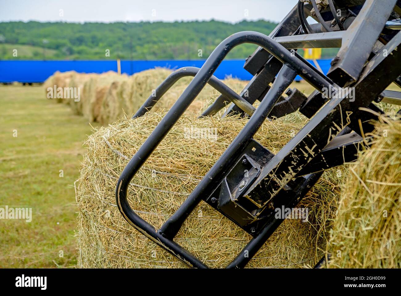 Detail of Tractor working in the field and raising the haystack Stock ...