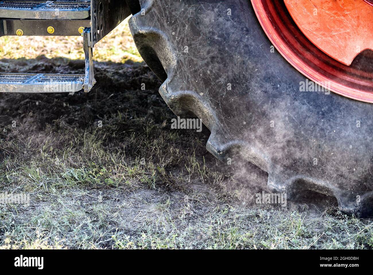 Powerful tractor wheels go over the ground up dust.A small movement ...