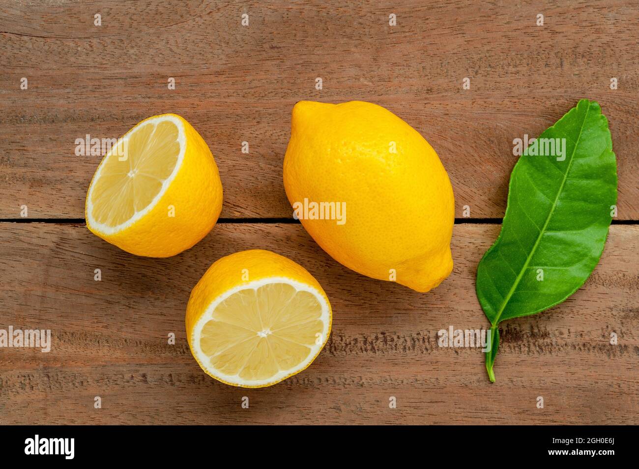 Fresh lemons and lemons leaves on rustic wooden background. Fresh ...
