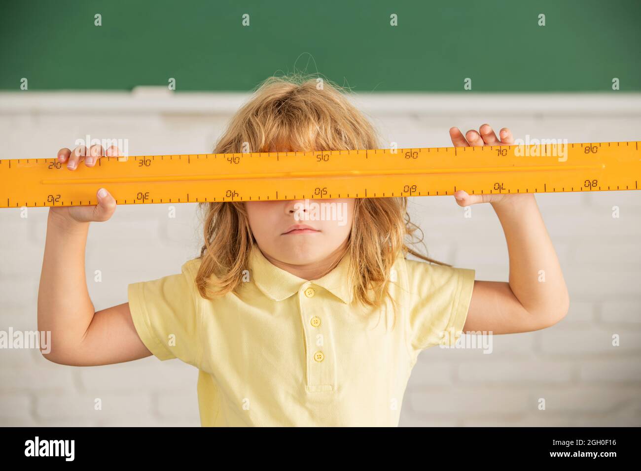 child boy in school holding math ruler tool, school Stock Photo - Alamy