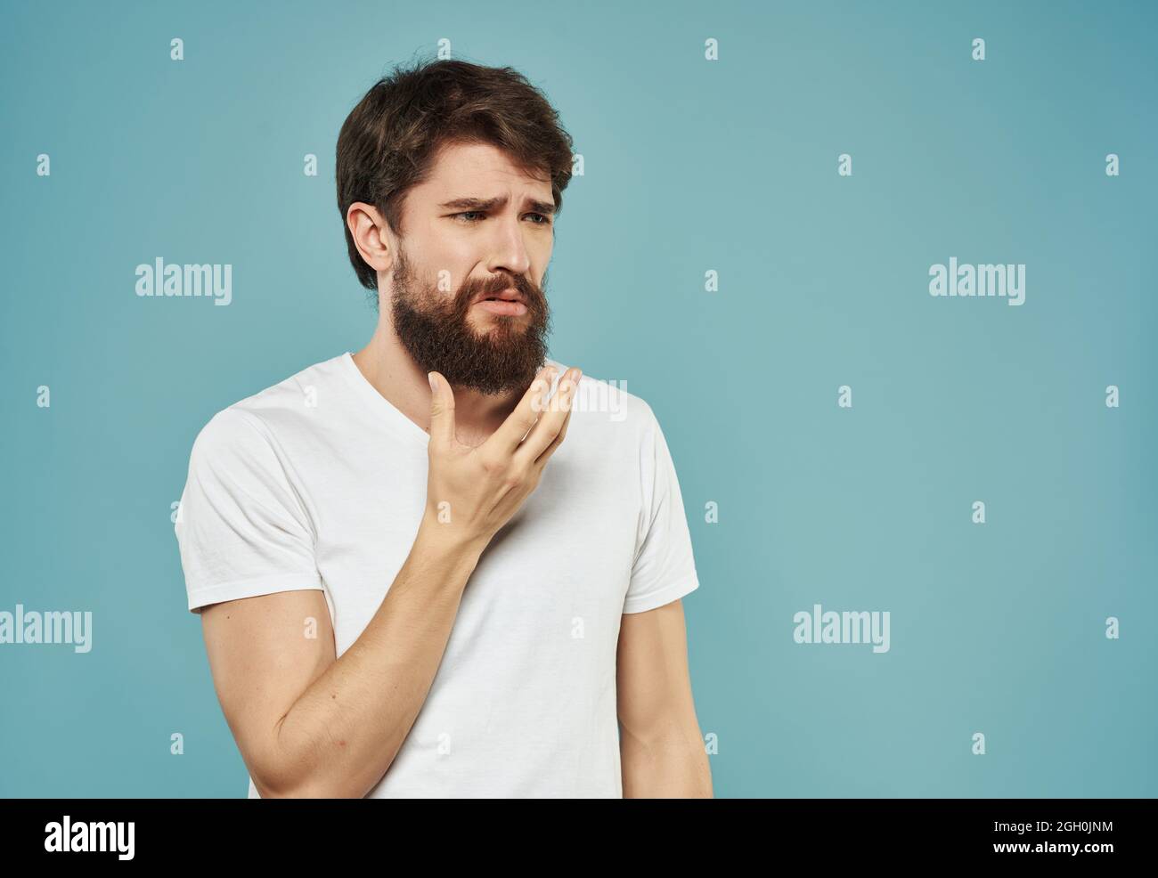emotional man in a white t-shirt irritated facial expression Studio ...