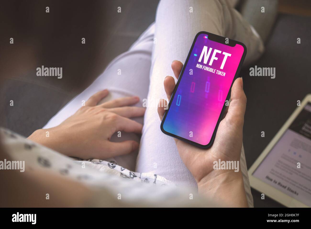 Smartphone screen with NFT logo in woman hand. Concept of crypto art ...