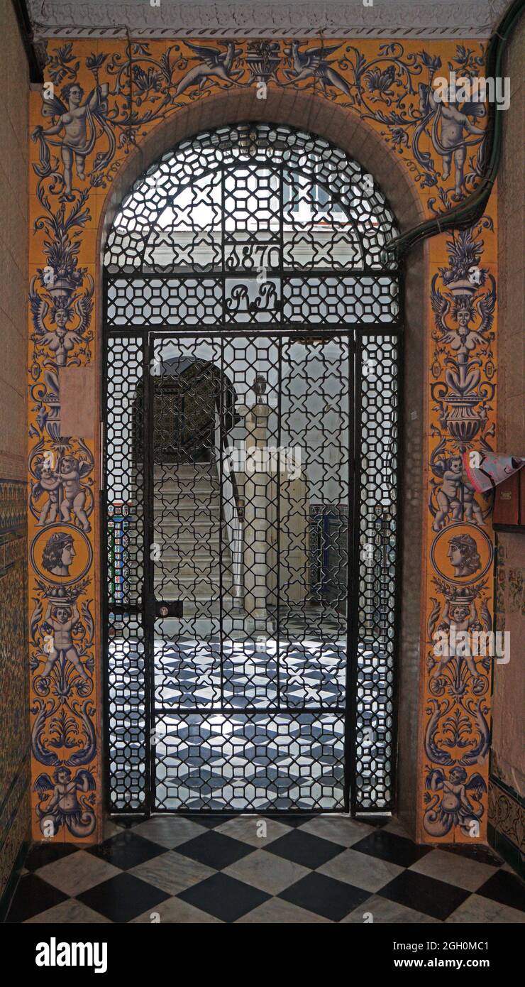the entrance of a traditional house with a metal barred door with ...