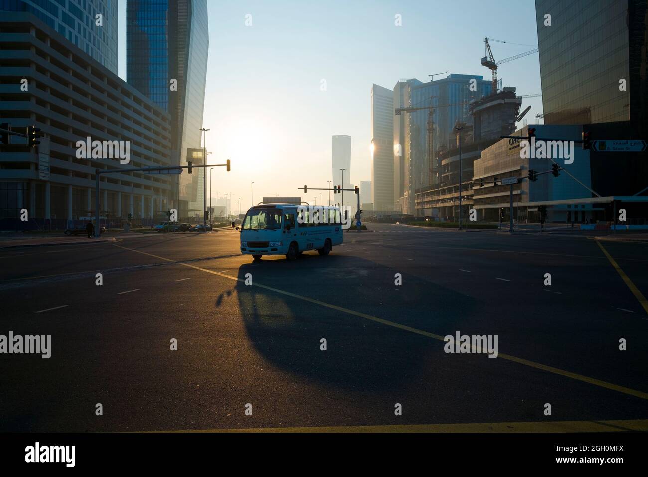 A van going through an intersection, backlit by late afternoon sun. In ...