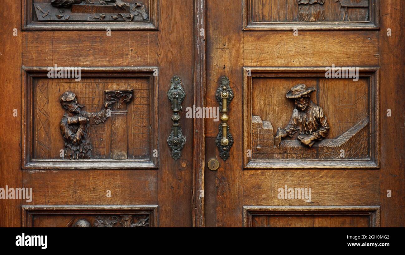 old heavy wooden door with two portraits of traditional workers at work ...