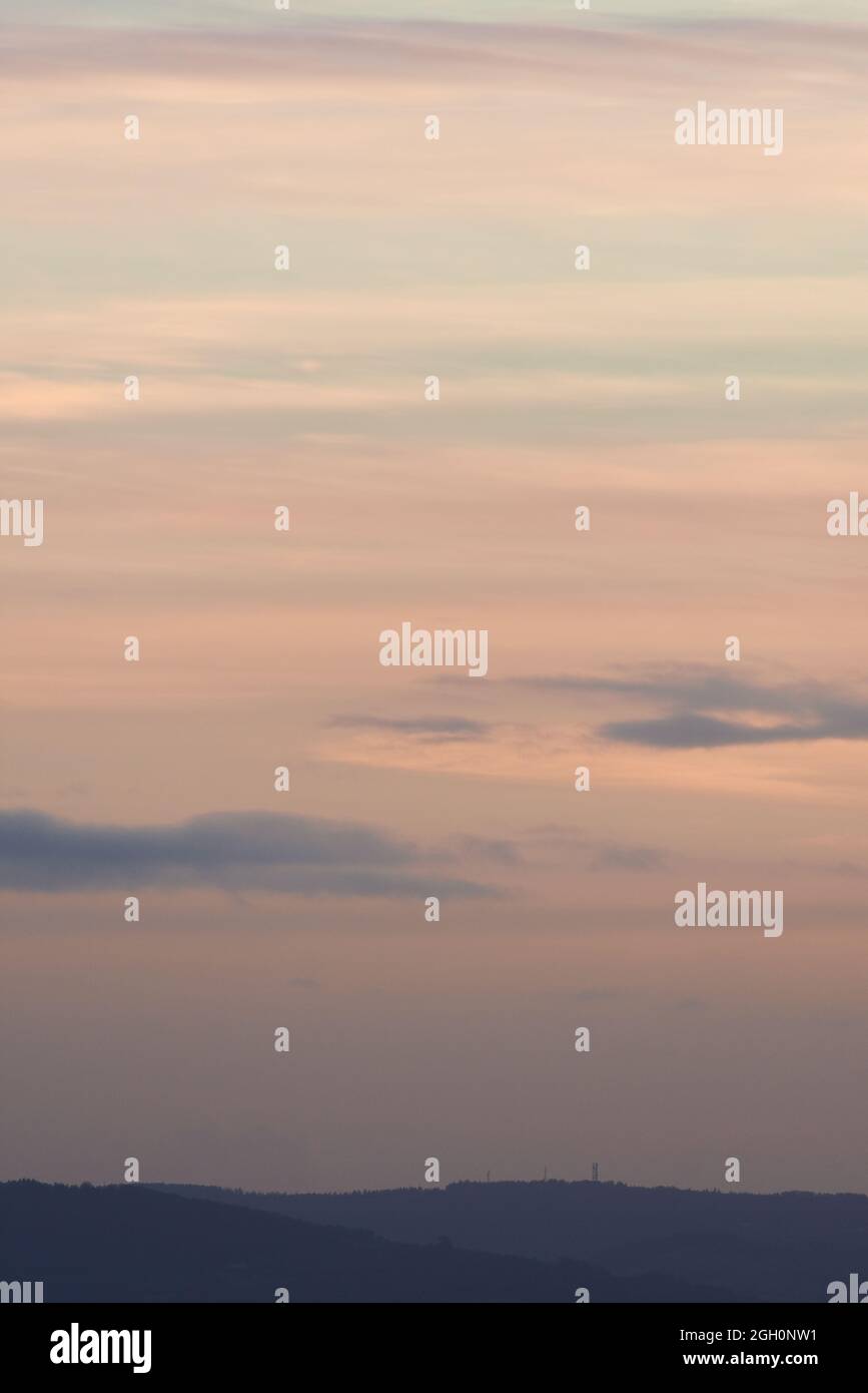 Vertical hazy sunset. Horizon under warm and faded pastel colours ...
