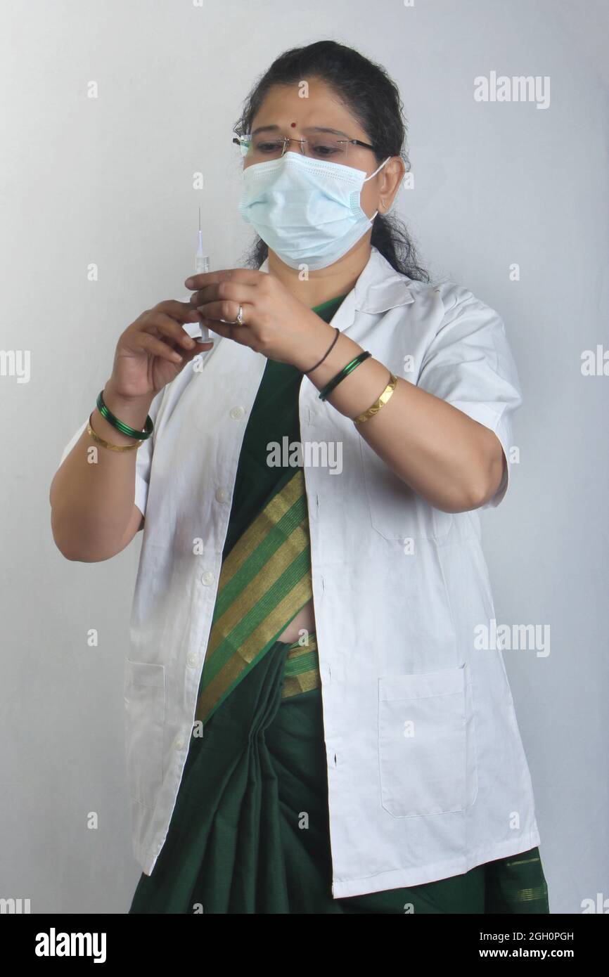 Vertical shot of a south Asian doctor preparing for an injection Stock ...