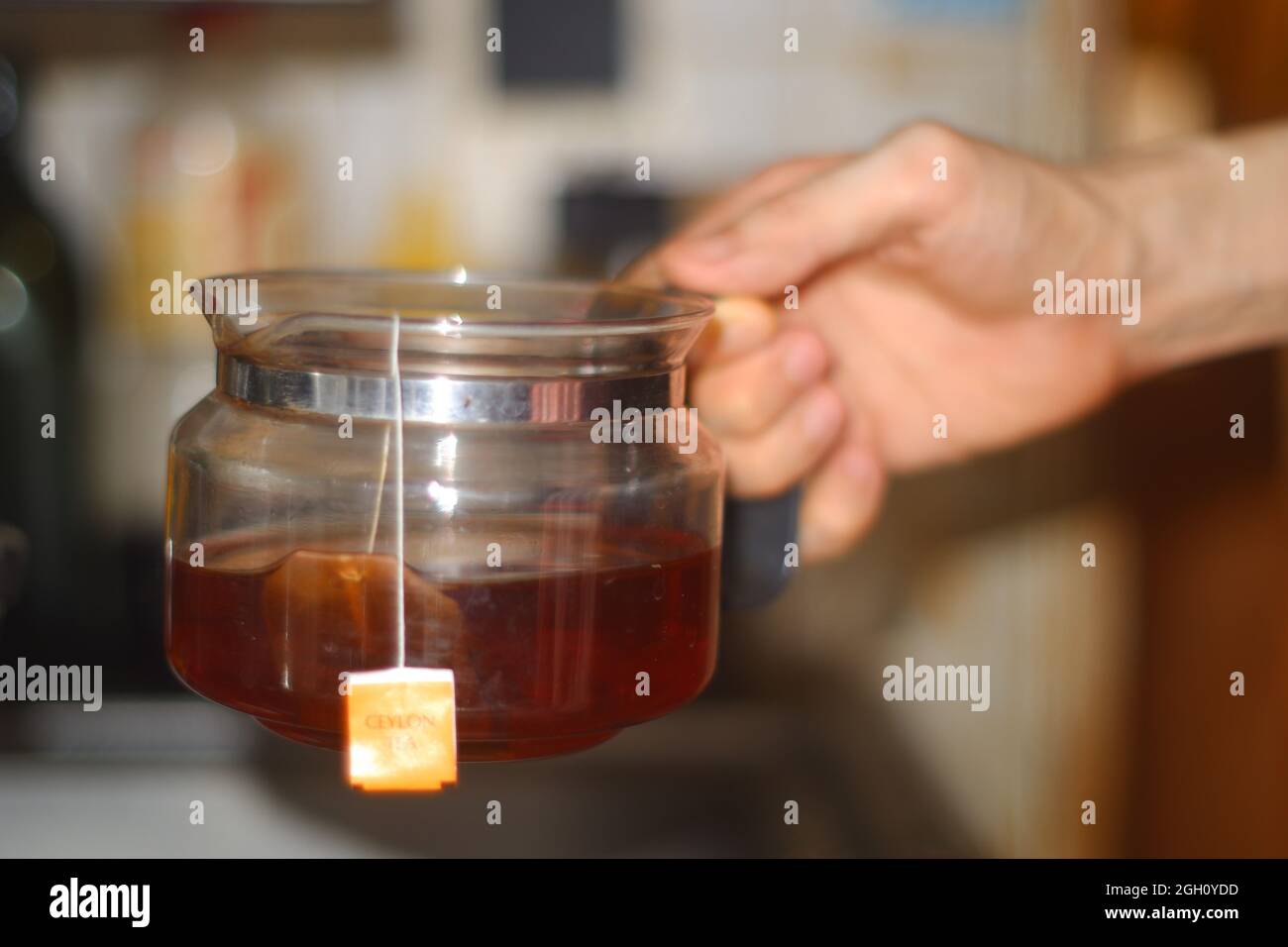 Tea infusing with glass tea pot and pouring into cups Stock Photo - Alamy