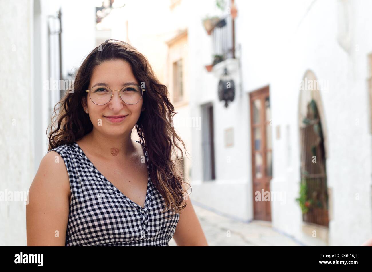 young female model poses in front of the city. beautiful woman smiles ...