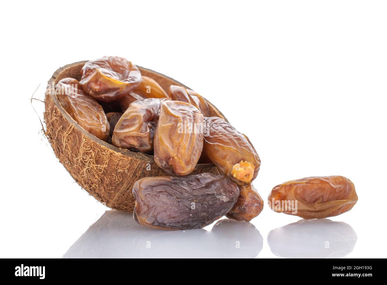 Several dried organic light brown dates in a coconut shell, close-up ...