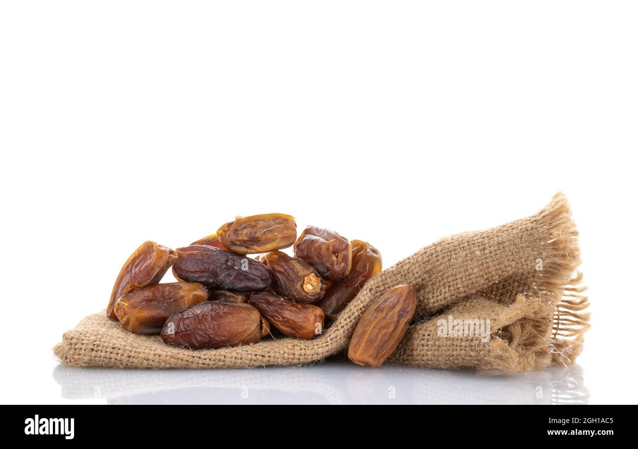 Several dried organic light brown dates with a jute bag, close-up ...