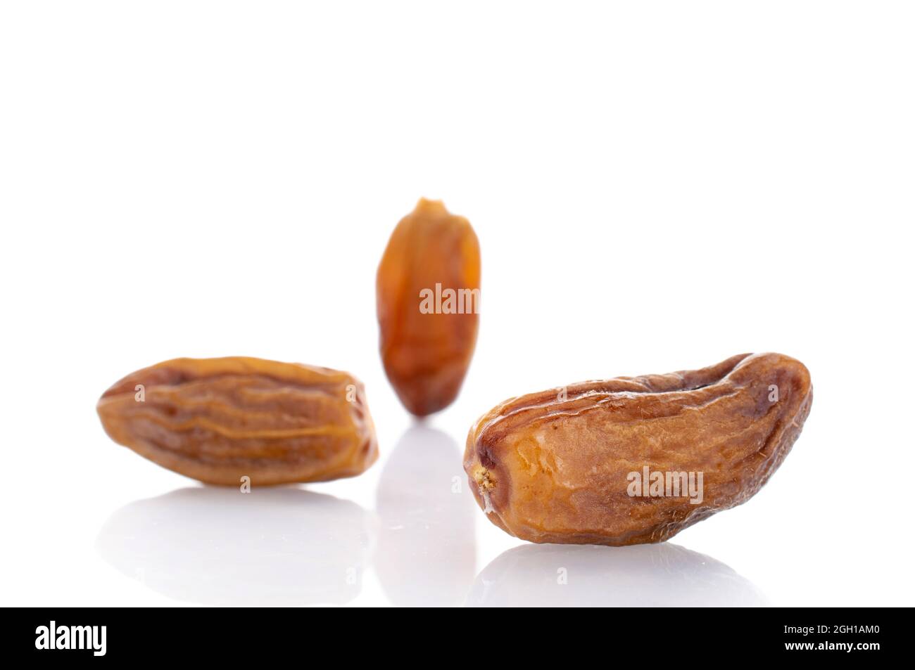 Three natural dried dates, close-up, isolated on white Stock Photo - Alamy