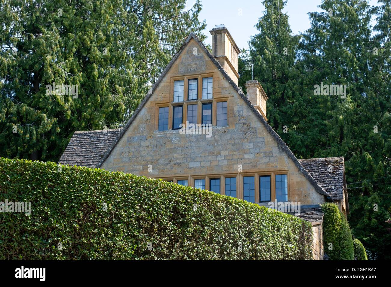 Attractive stone cottage particially obscured behind tall box hedge in ...