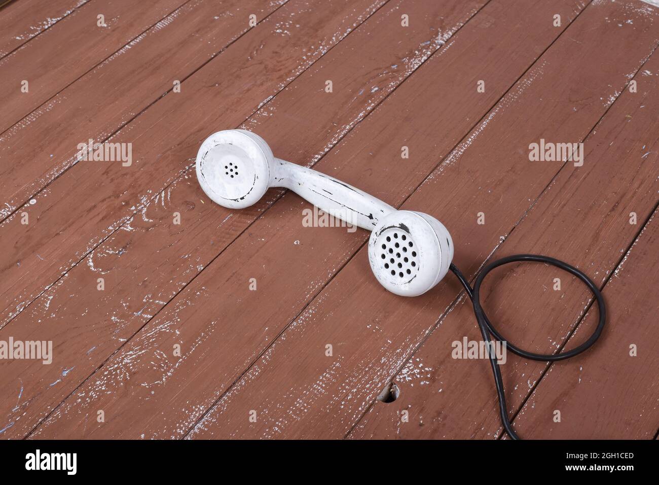 White handset vintage phone on a retro old brown wood textured plank ...