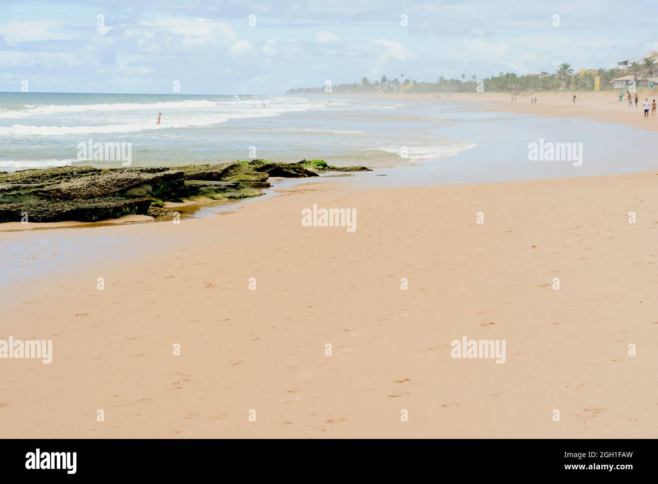 Sand water and stones of Arembepe beach on a sunny day. Camaçari, Bahia ...