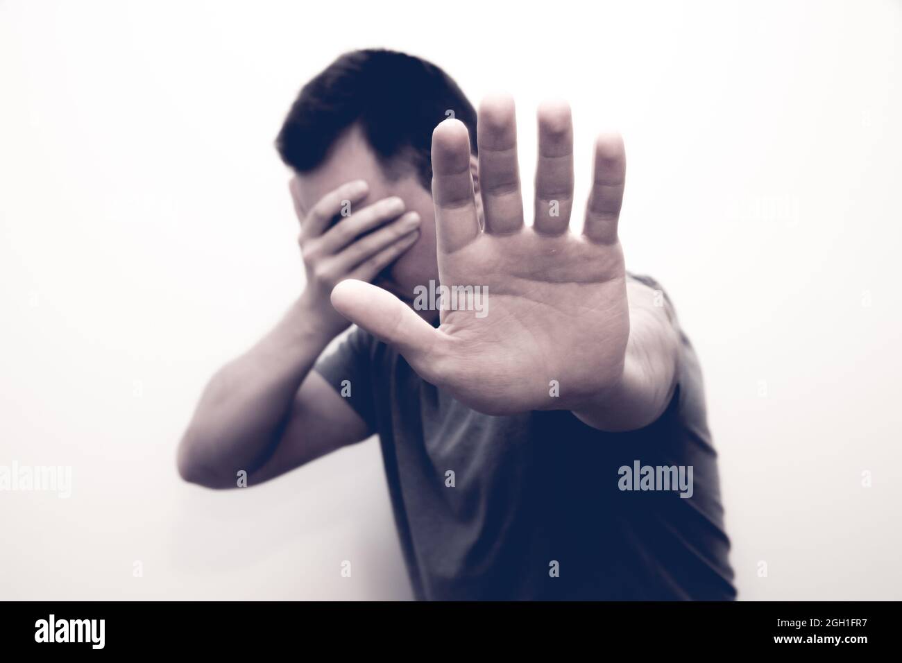 Man raising a hand to prohibit or cover her face to show resistance ...