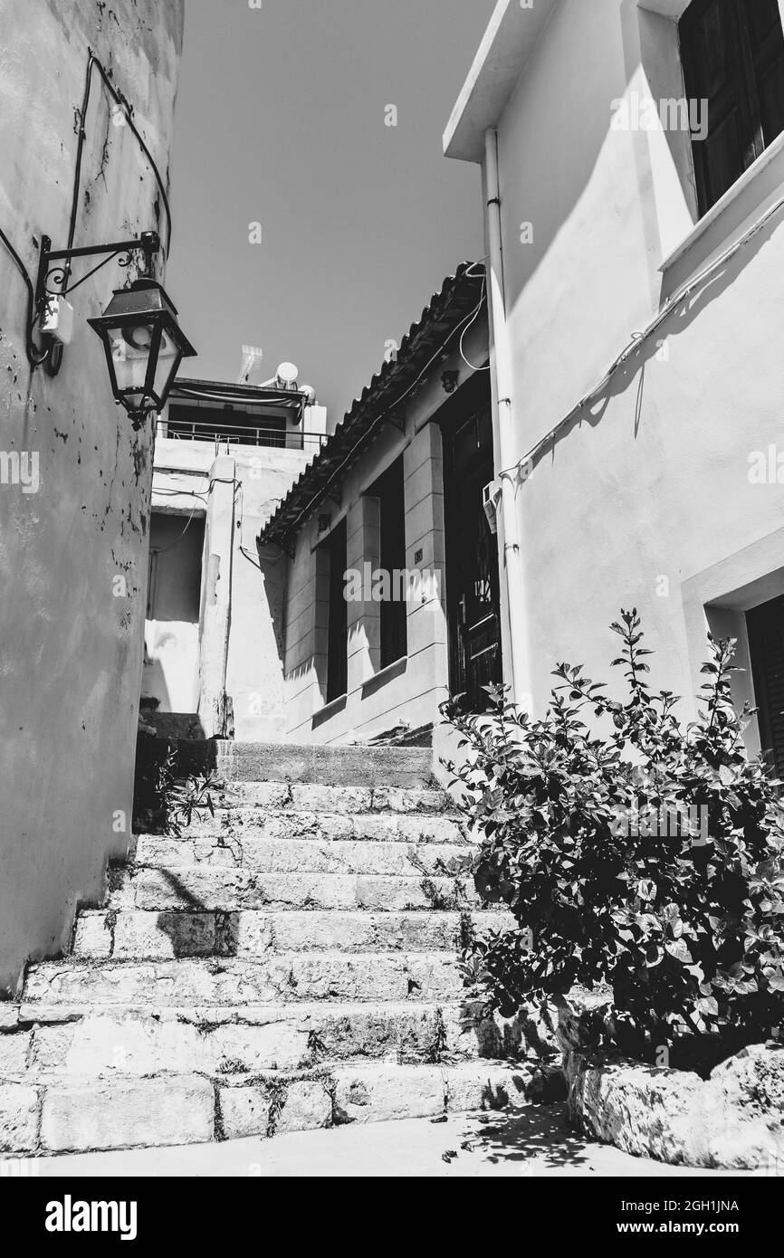 Grayscale shot of an alley with stairs surrounded by houses in a rugged ...