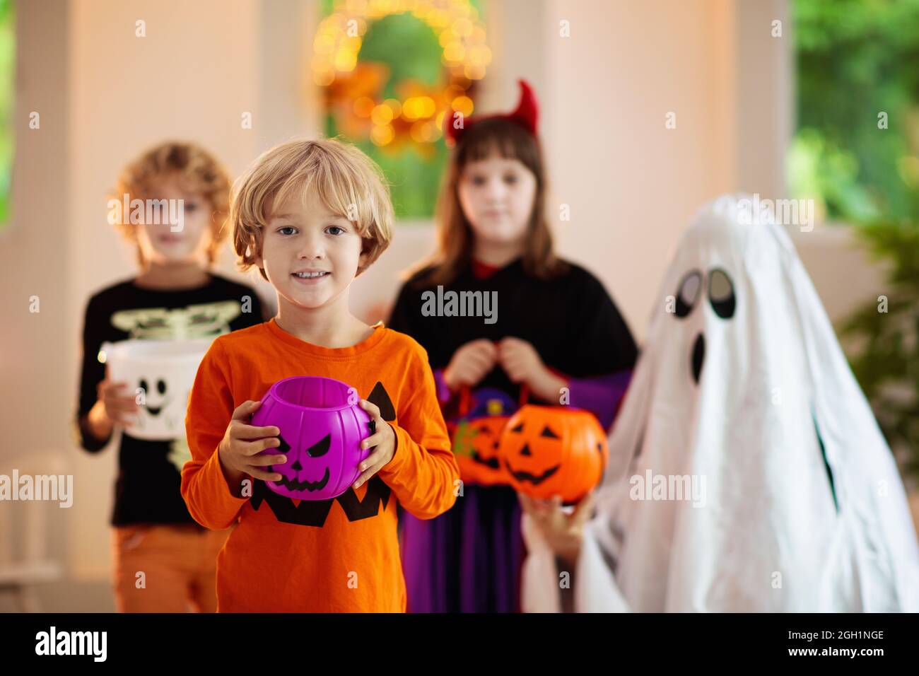 Kids trick or treat in Halloween costume. Children in colorful dress up ...