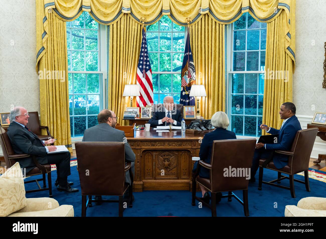President Joe Biden meets with staff in the Oval Office of the White ...