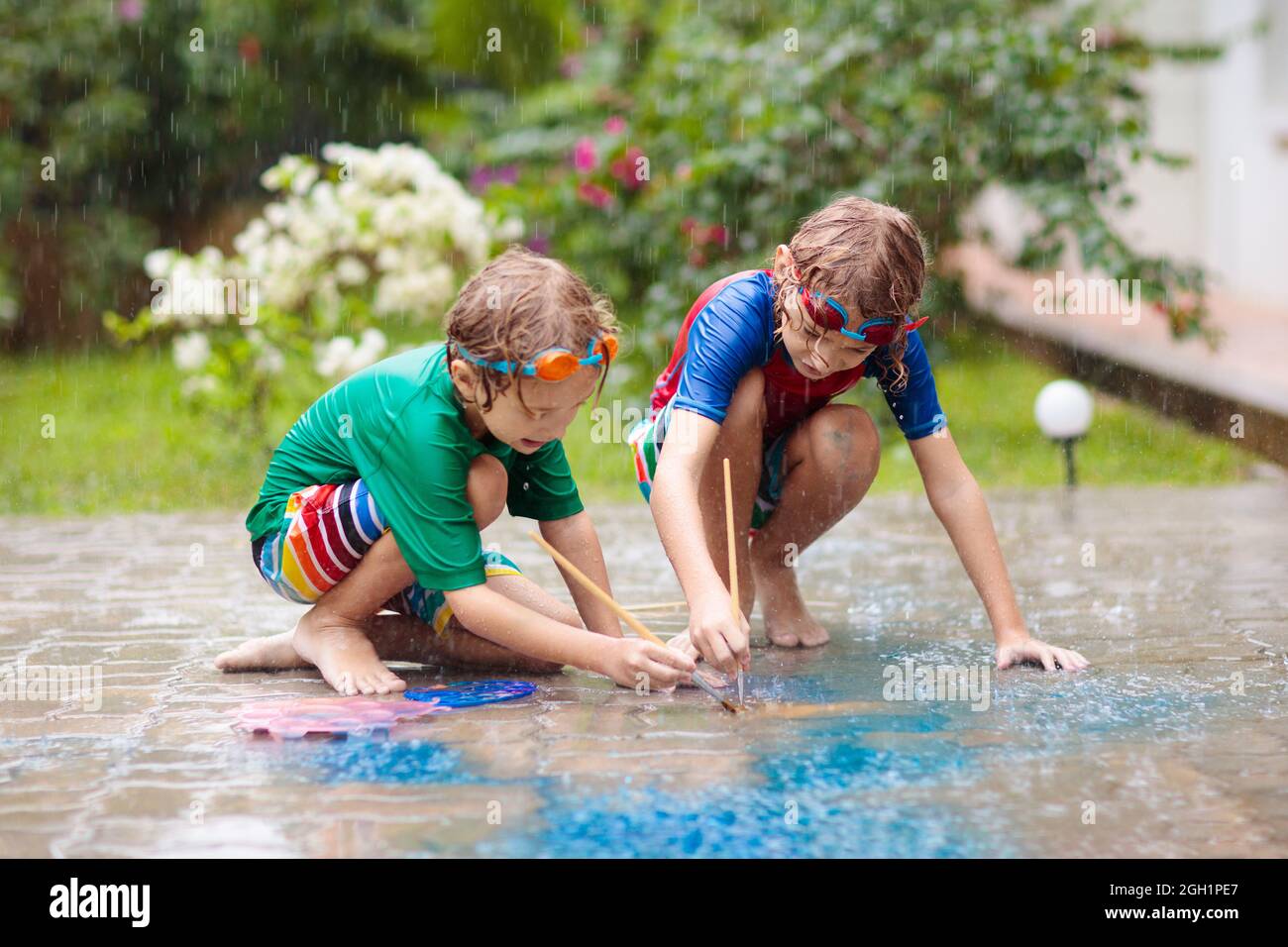 Kids playing in the rain. Chalk drawing fun. Art and crafts for young ...