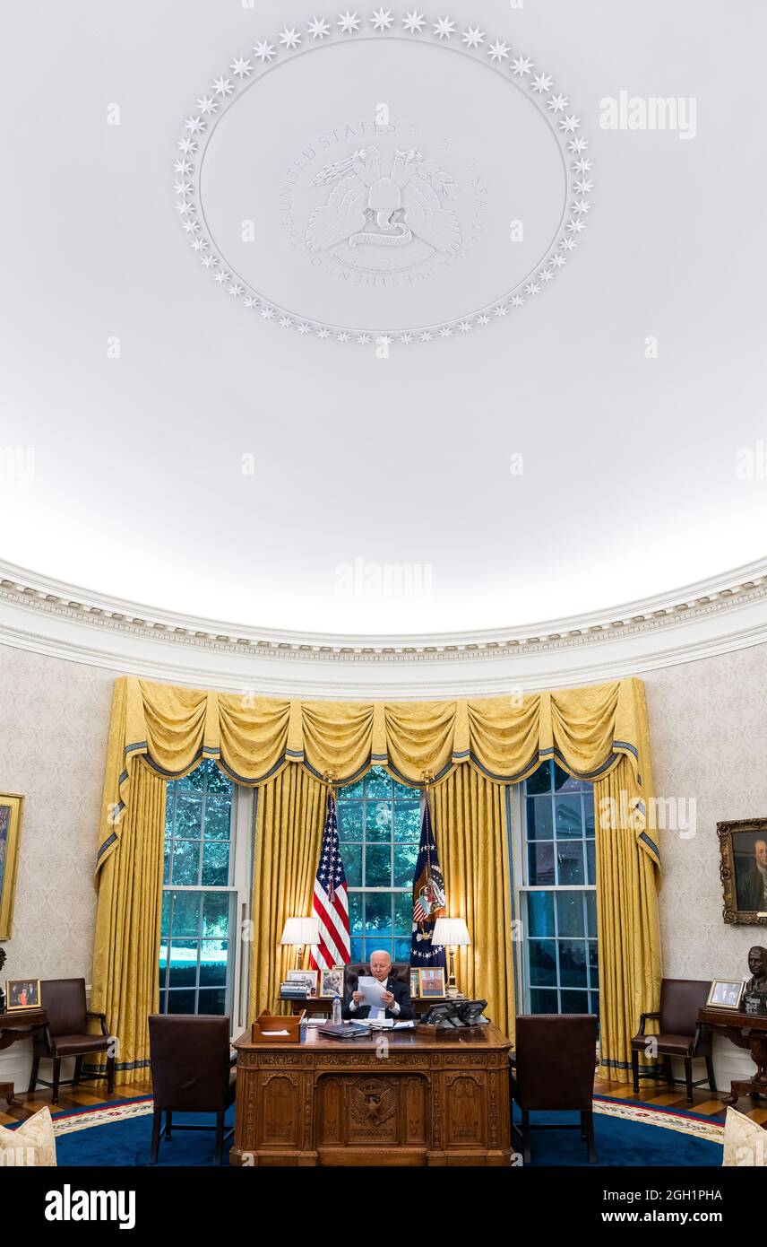 President Joe Biden looks over notes at the Resolute Desk, Wednesday ...