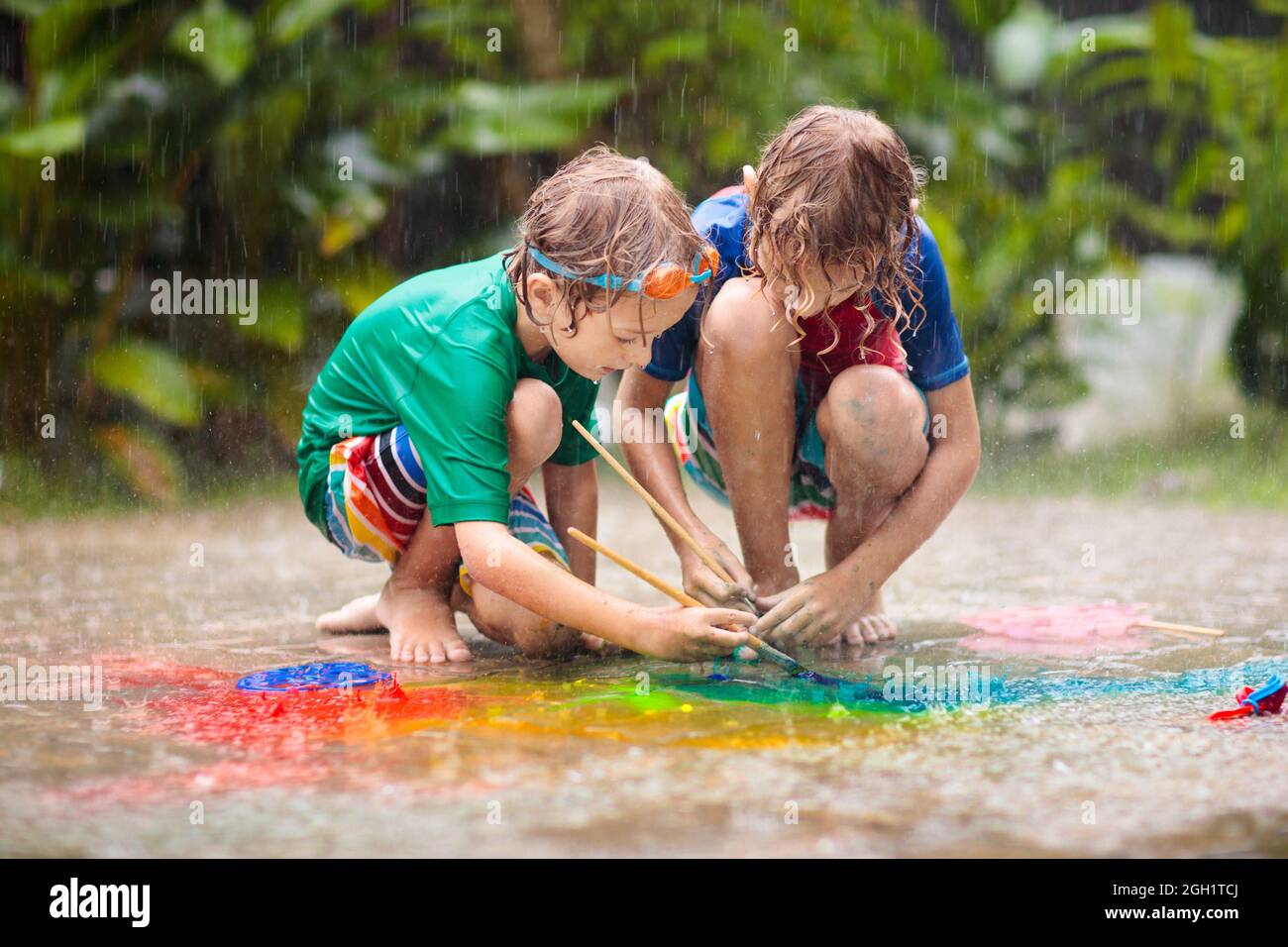 Kids playing in the rain. Chalk drawing fun. Art and crafts for young ...