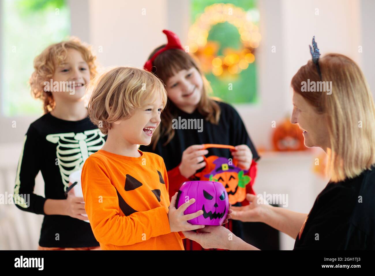 Kids trick or treat in Halloween costume. Children in colorful dress up ...