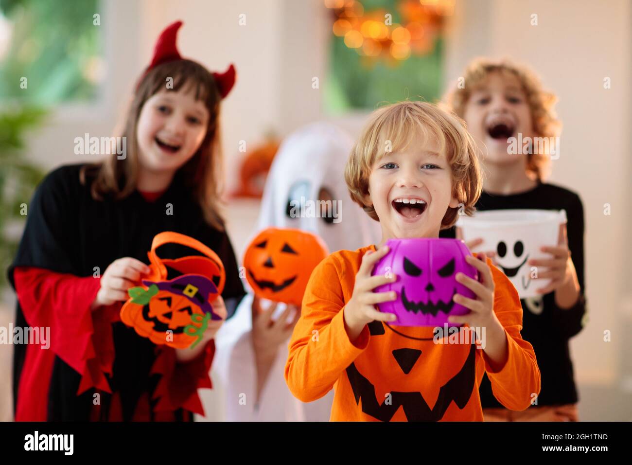 Kids trick or treat in Halloween costume. Children in colorful dress up ...