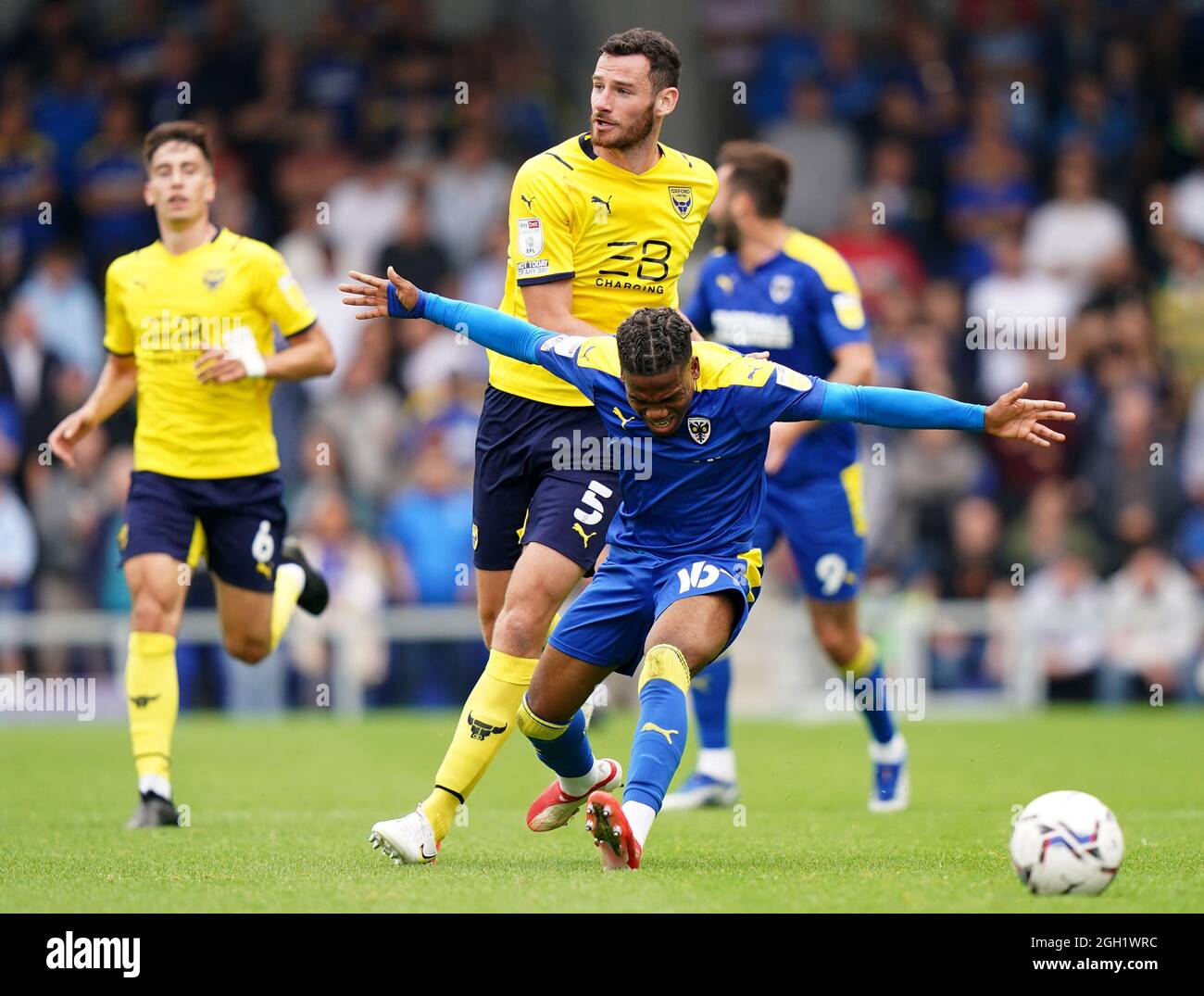 Oxford United's Elliott Moore (left) and AFC Wimbledon's Dapo Mebude ...