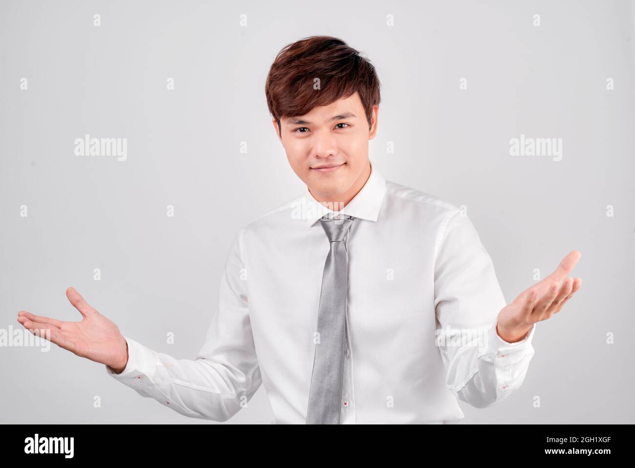 Happy asian man greeting somebody over white background. Looking at ...