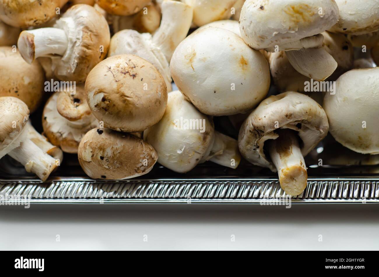 Portobello and white mushrooms on a silver plate, vegetables from an ...