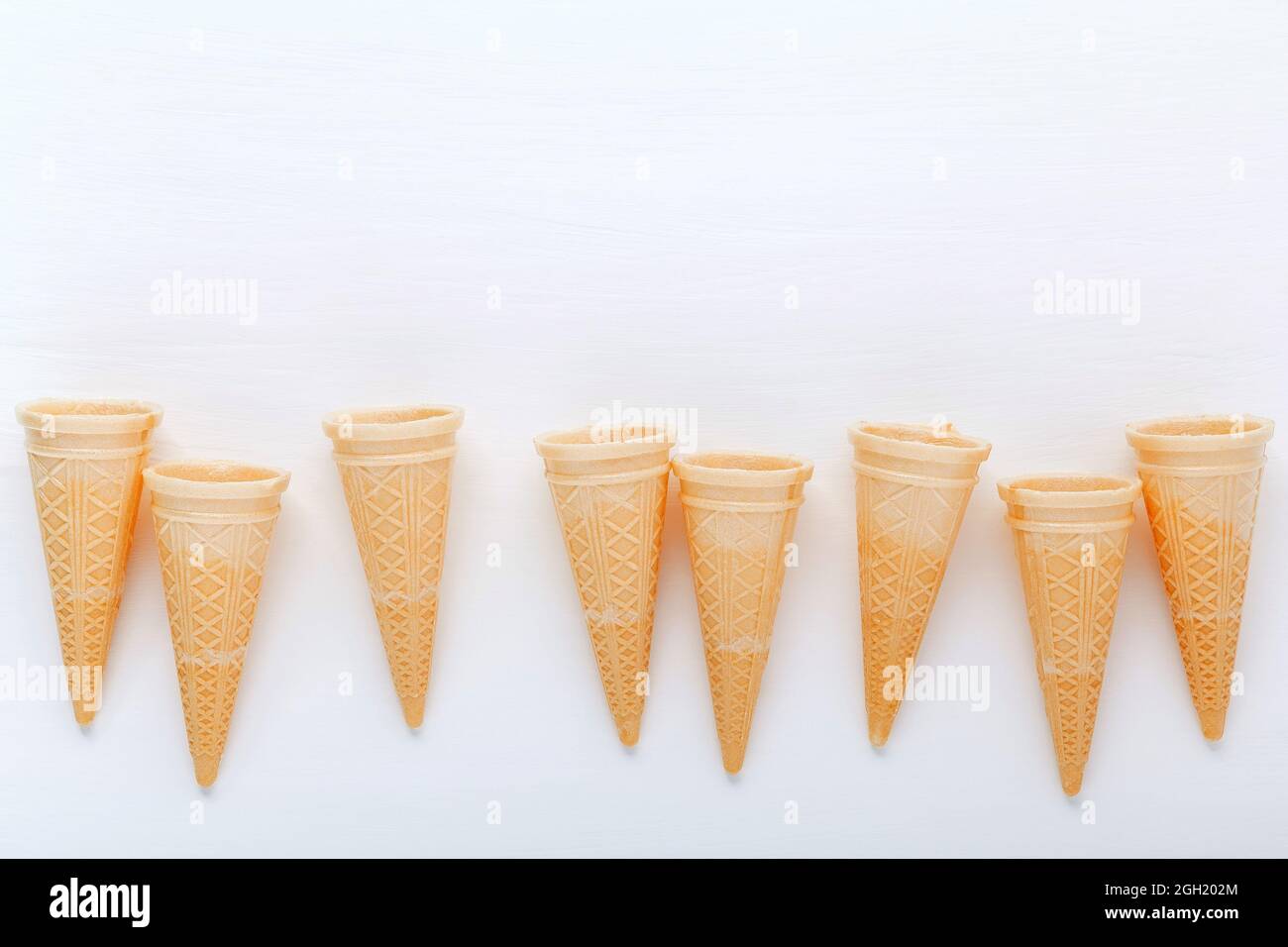 Flat lay ice cream cones collection on white wooden background . Blank ...