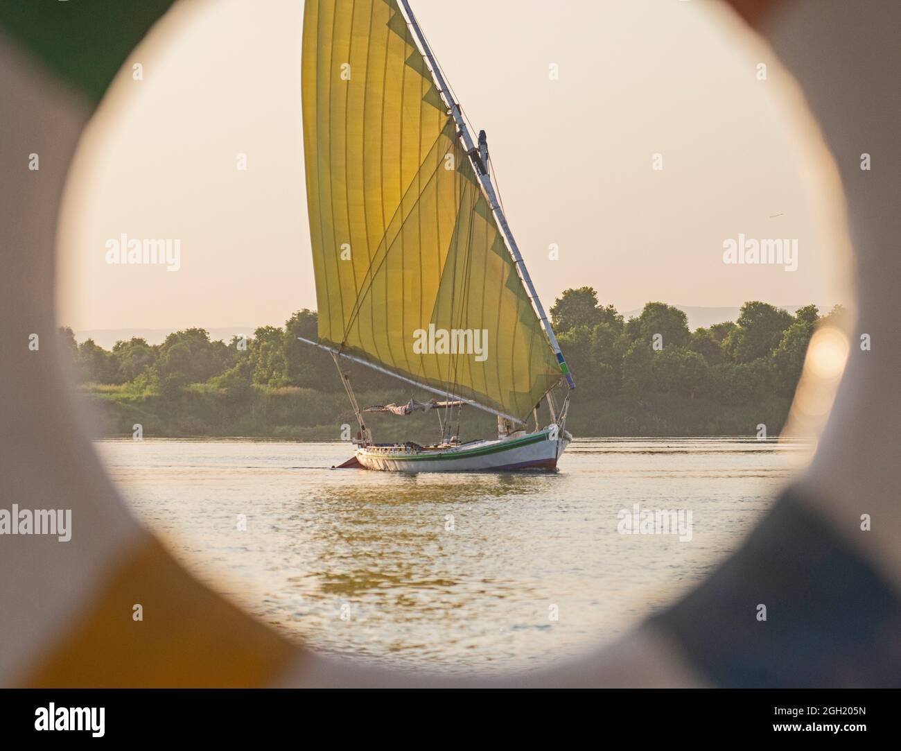 Tropical river bank with traditional sailing felluca boat on water ...