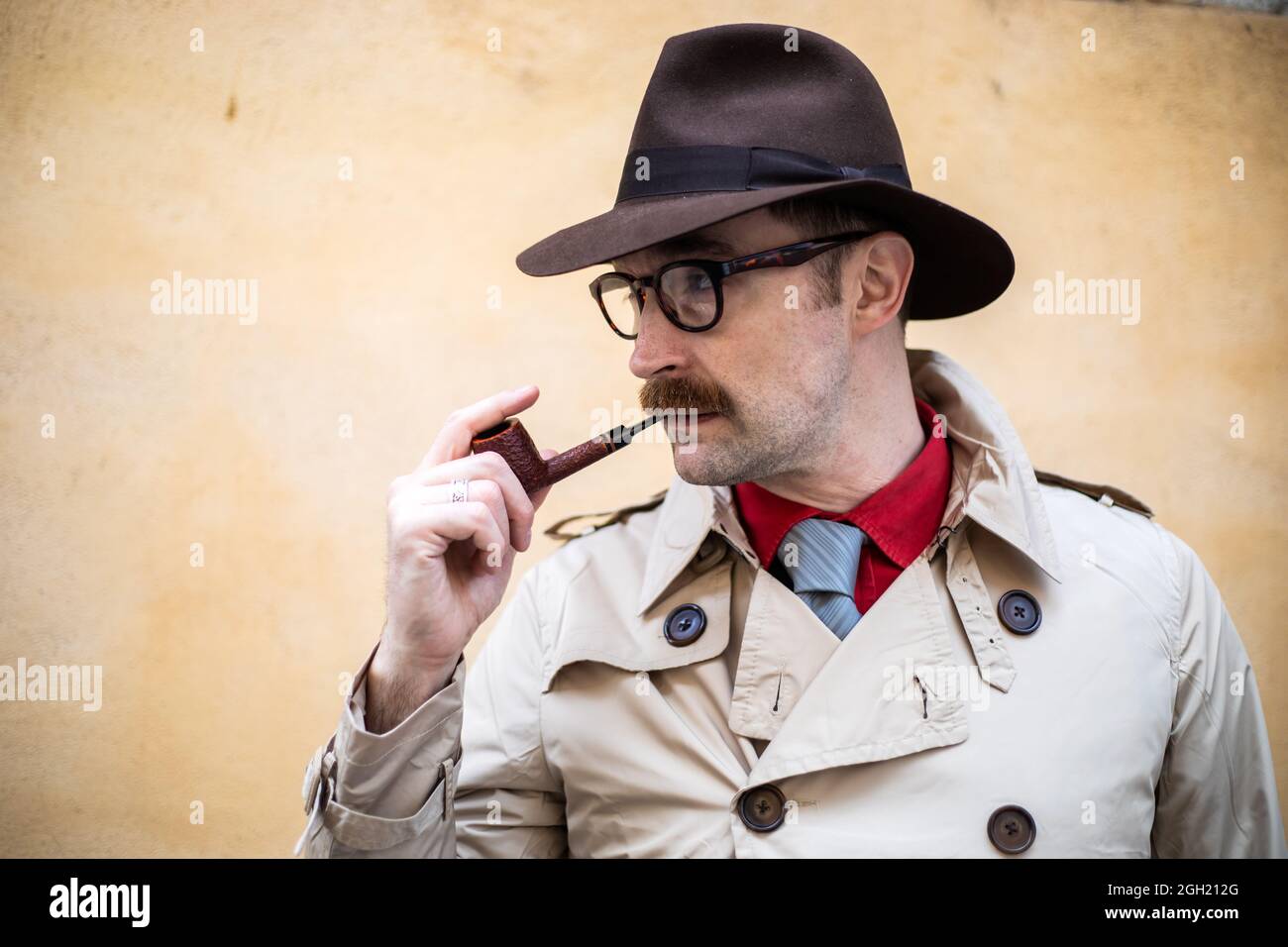 Vintage detective smoking a pipe outdoor in a grungy environment Stock ...